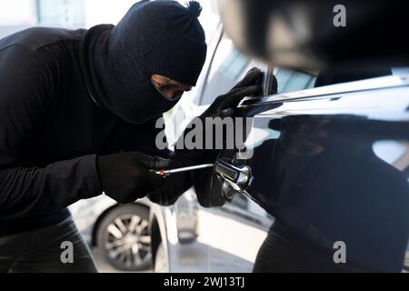 A young man who is breaking into a car Stock Photo - Alamy