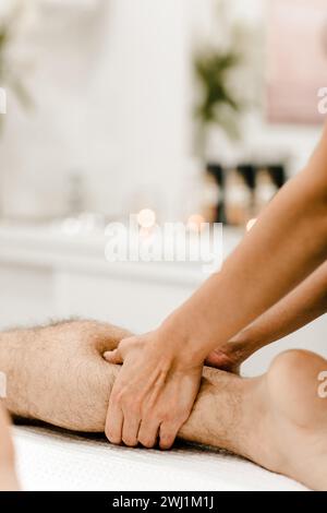 Detailed view of a leg massage on a man, focusing on muscle relaxation ...