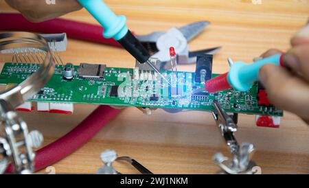 Technicians are repairing motherboards and checking electrical currents ...