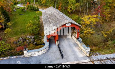 Aerial View of a Burr Truss Covered Bridge Crossing a Stream on an ...
