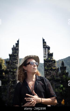 Young hispanic man tourist wearing backpack using smartphone at street ...