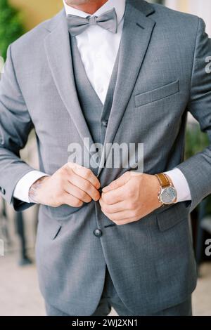 The groom buttons his jacket Stock Photo - Alamy