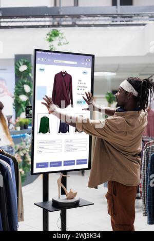 Client using touch screen board in trendy clothing store, shopping for ...