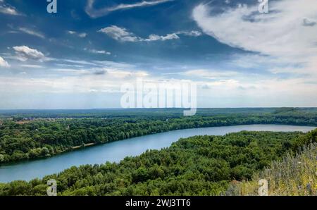 Aerial view of a wide river meandering through rolling hills and lush ...