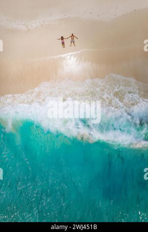 Aerial view of a woman laying down on the pier along the coastline ...