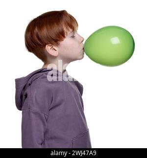 Boy inflating green balloon on white background Stock Photo - Alamy
