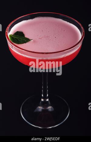 Red, sweet berry cocktail with froth, decorated with raspberries on a ...