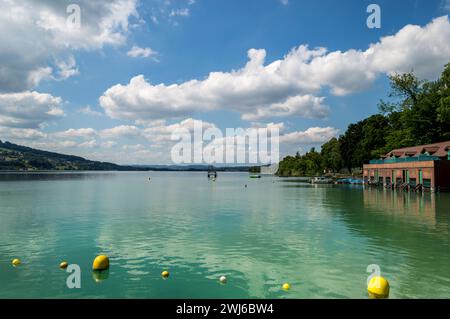 Shot over lake Hallwil in Switzerland on a summer's day with blue sky and white clouds. Green ...