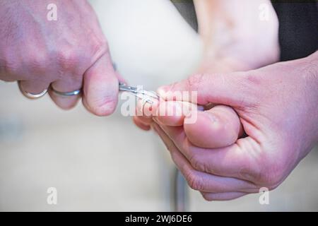 cut nails from men's feet with nail scissors at home. Foot and nail ...