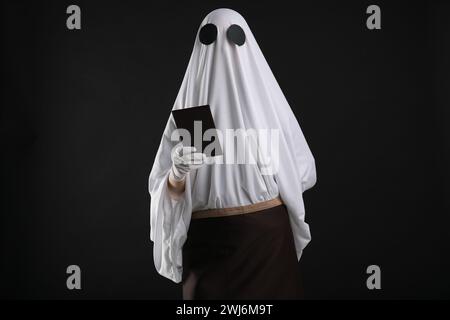 Creepy ghost. Waiter in white sheet and apron with receipt on black ...