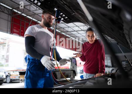 Mechanic and customer inspecting car in auto repair shop Stock Photo ...
