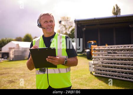 Male Production Worker With Headset Setting Up Outdoor Stage For Music ...