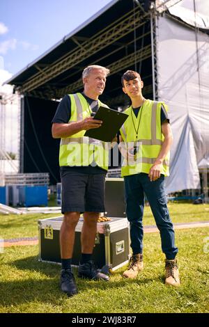 Male Production Team With Flight Cases Setting Up Outdoor Stage For ...