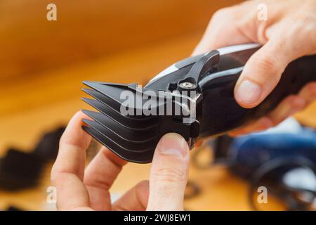 Hairdresser changing the comb of his hair clipper machine. Replacing ...
