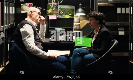 Law officers analyze greenscreen on phone display, working on new crime ...