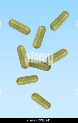 Vitamin. Capsules falling on light blue gradient background Stock Photo ...