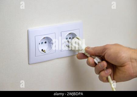 The man plugs in the cord. Selective focus Stock Photo - Alamy