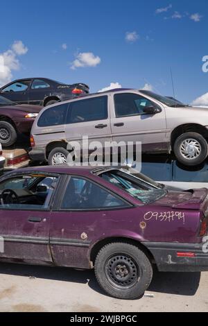 Stacked automobiles and mini van at scrap metal recycling junkyard ...