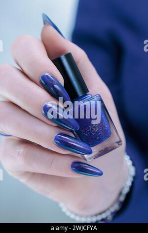 Woman's beautiful hand with long nails and light blue manicure with ...