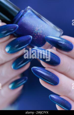 Woman's beautiful hand with long nails and light blue manicure with ...