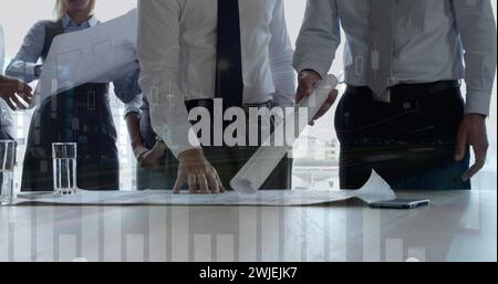 Architects discuss a building plan with graphs Stock Photo - Alamy