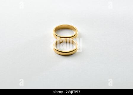 Detail of engagement gold rings forming an eight on white isolated ...