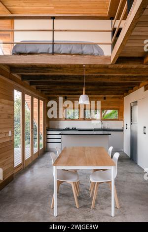 Double-height interior with living quarters, stairway and skylight ...