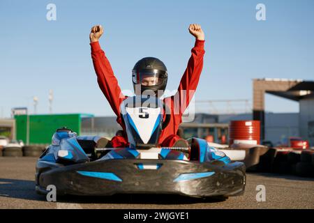 Happy go-cart driver raising hand up rejoicing and celebrating win ...