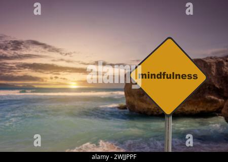 Road sign with mindfulness text and ocean view with sunset scene ...