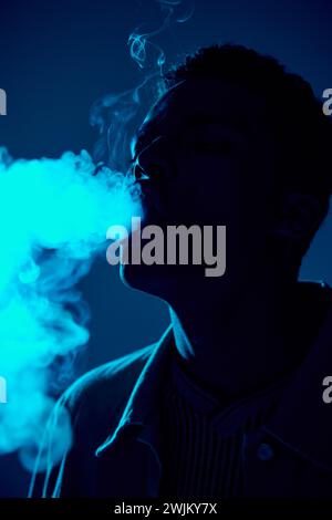 portrait of african american man exhaling smoke against vibrant ...