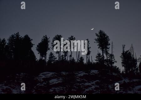 Crescent moon rises over mountain Stock Photo - Alamy