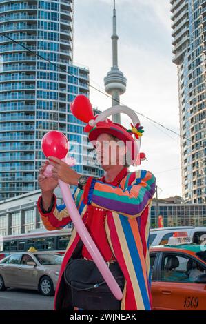 Street artists inflating animal balloons in downtown district, Toronto ...