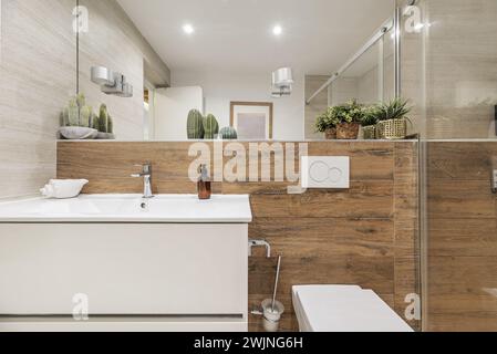 Bathroom with wood-look tile wall, designer white porcelain sinks, and ...