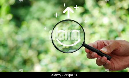 Hand holding a magnifying glass highlighting a happy smile. Concept of ...