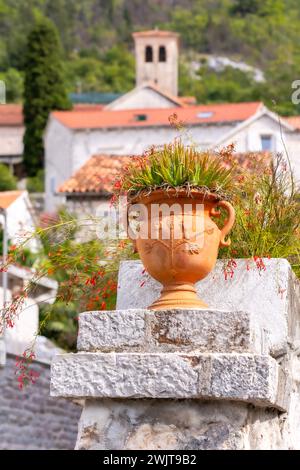 Town flowers in the big clay pots on street. Interior park street with ...