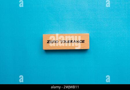 Zero tolerance words written on green torn paper piece with cardboard background. Conceptual ...
