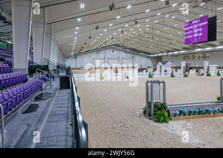Riders prepare for hunter jumper competition at an indoor arena at the ...