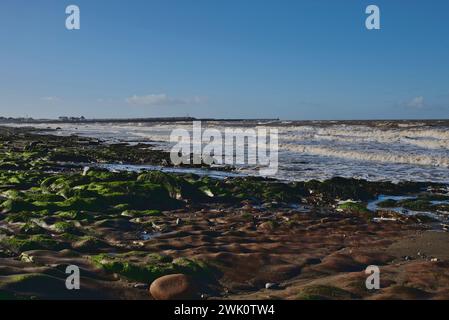The harbour with Spring Tidal waves over the beach at Maryport, Cumbria ...