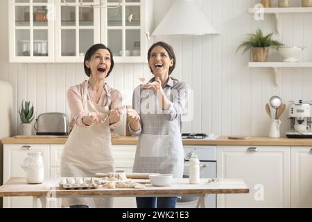 Mother and daughter having fun cooking together in kitchen Stock Photo ...