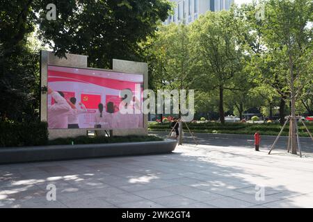 A propaganda video of the CCP is being shown on a screen in Shanghai's ...