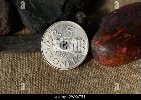 A coin with a hole 5 Kroner Harald V 1999. Norwegian coin on linen ...