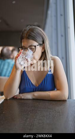 Savor the freshness, beautiful hispanic woman sips cold, clear water in ...