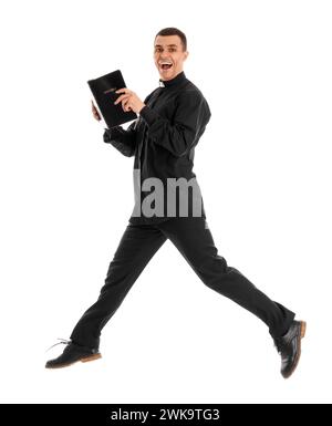 Young priest with Holy Bible jumping on white background Stock Photo ...