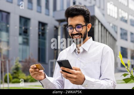 A young man, an Asian businessman chooses wine in the alcohol section ...