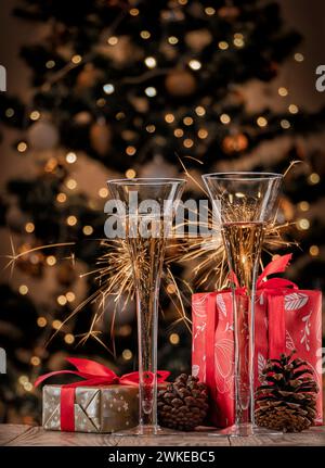 Champagne bottle with burning Christmas sparklers on color background ...