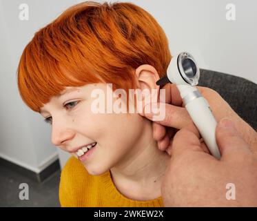 Audiologist examining child's ear with otoscope. Otoscopy and hearing ...
