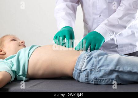 The doctor palpates the abdomen of a little girl who has pain and ...