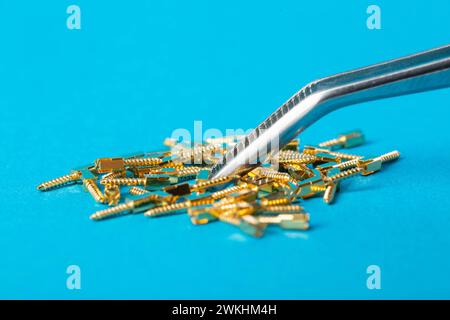 Metal dental pins on a blue background in tweezers in dentistry ...