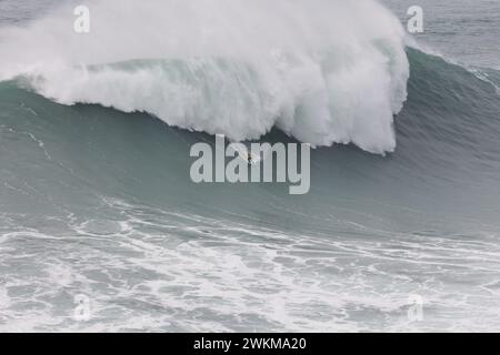 A big wave surfer rides a wave during a surfing session at Praia do ...