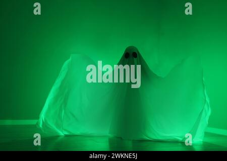Creepy ghost. Woman covered with sheet in blue light Stock Photo - Alamy